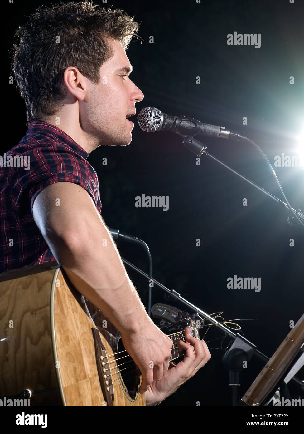 young musician playing acoustic guitar and singing, concert photo, for ...