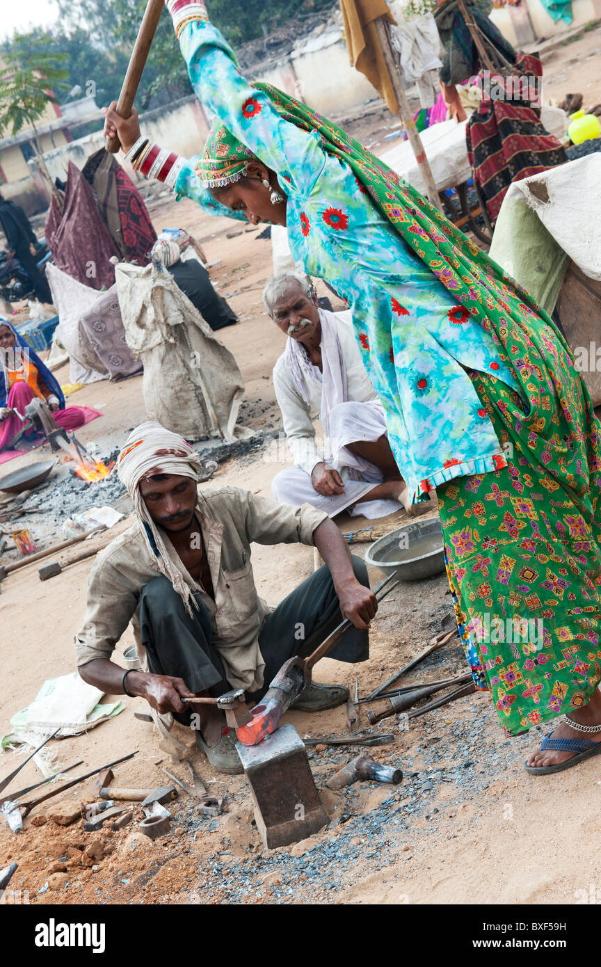Gadia Lohar. Nomadic Rajasthan men and woman forging metal axe heads ...
