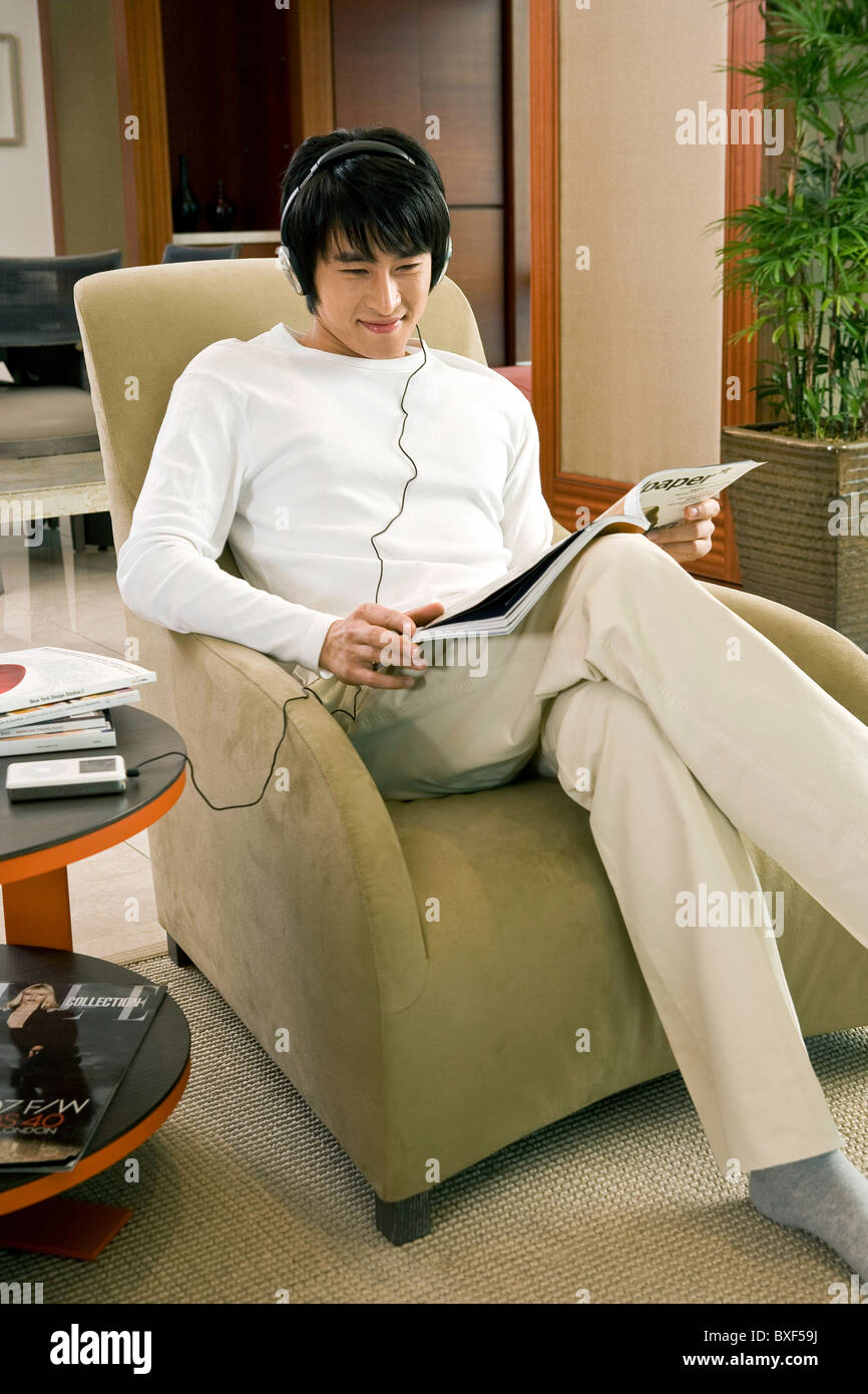 A young man reading a magazine with music Stock Photo - Alamy