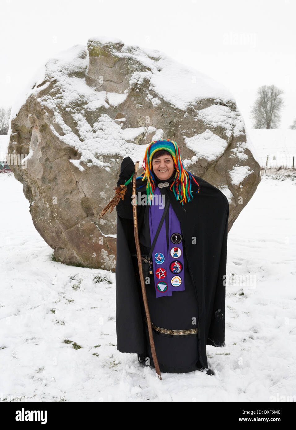 A druid celebrating the Winter Solstice in the snow at Avebury stone ...