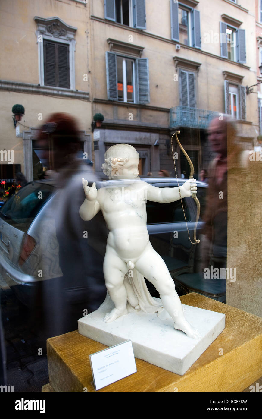 White marble statue of a cupid in the window of an antique shop in Rome ...