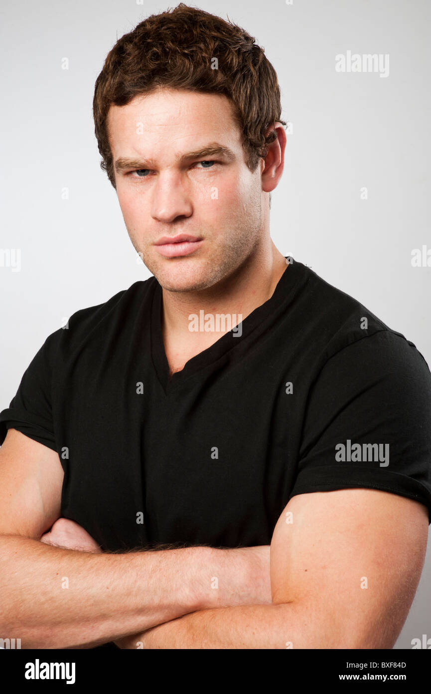 Aggressive young man arms folded hi-res stock photography and images ...