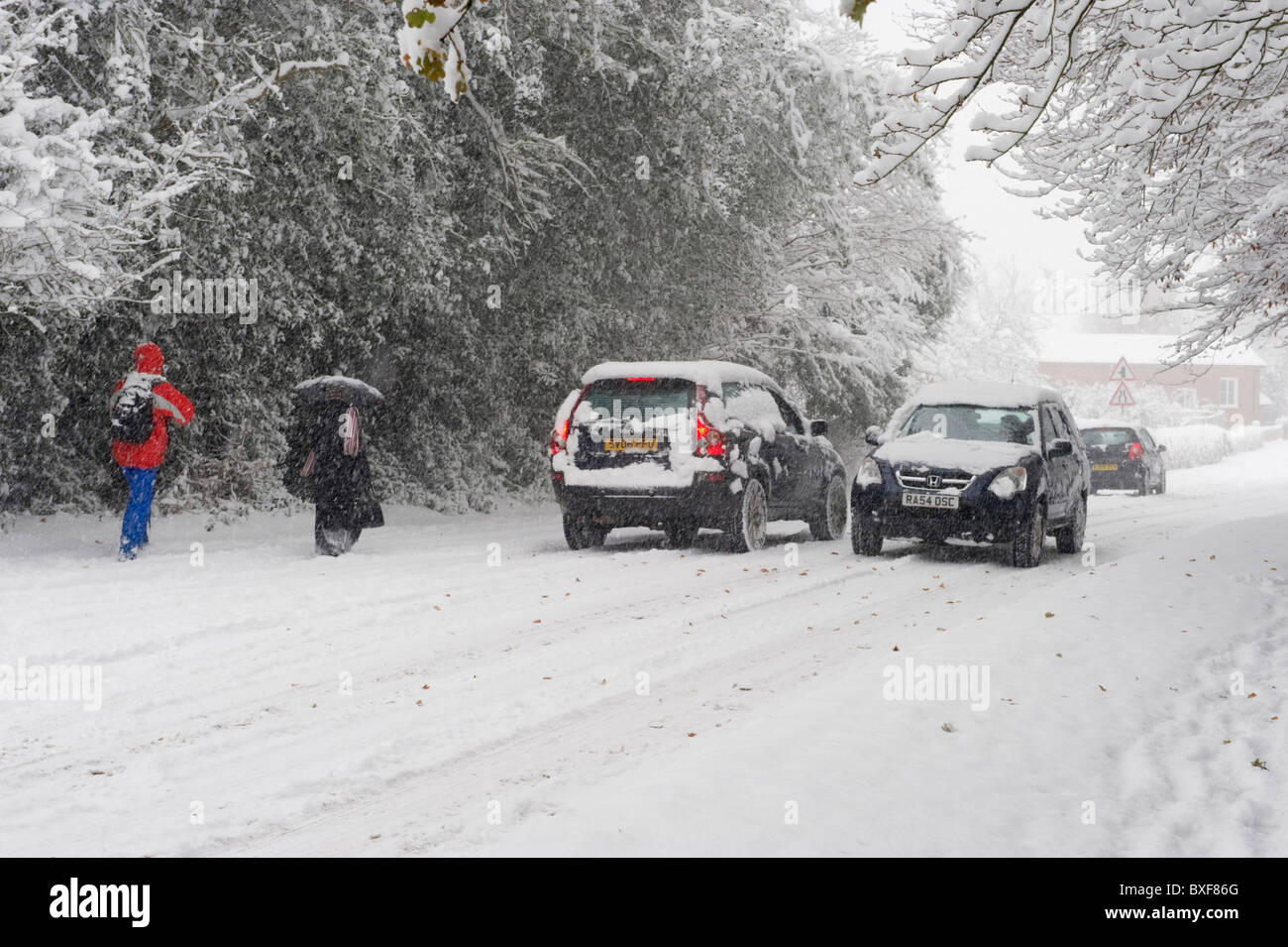 cars and pedestrians drive and walk very slowly through heavy snowfall ...