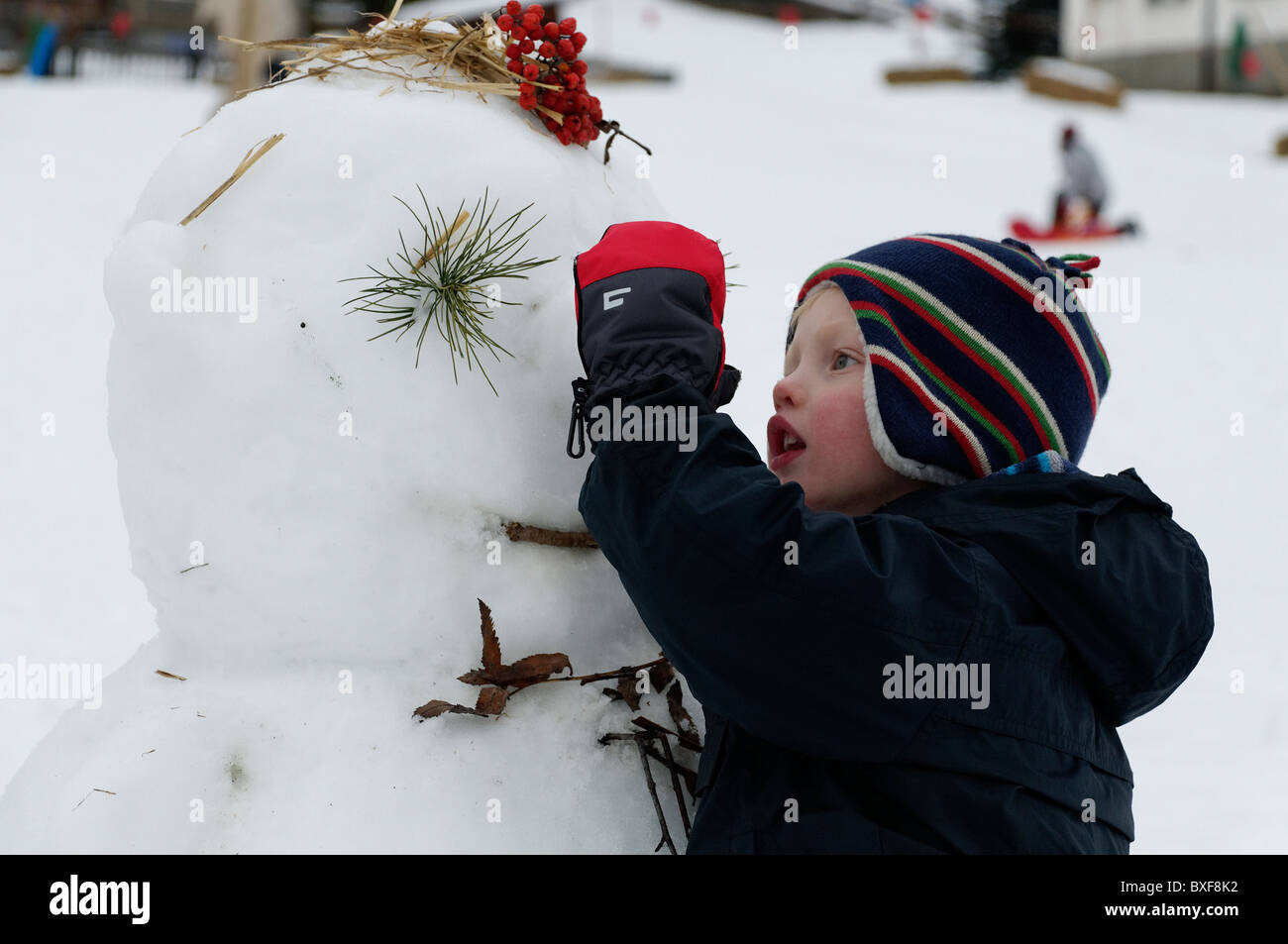 A young boy building a snowman Stock Photo - Alamy