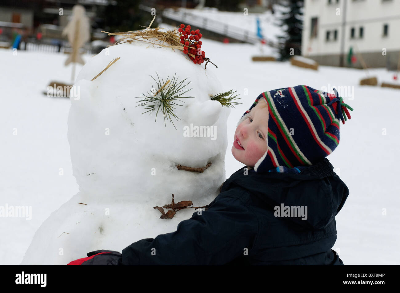 A young boy building a snowman Stock Photo - Alamy
