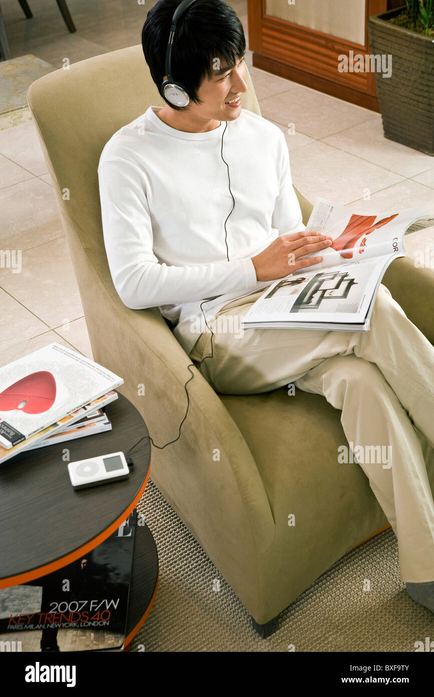 A young man reading a magazine with music Stock Photo - Alamy