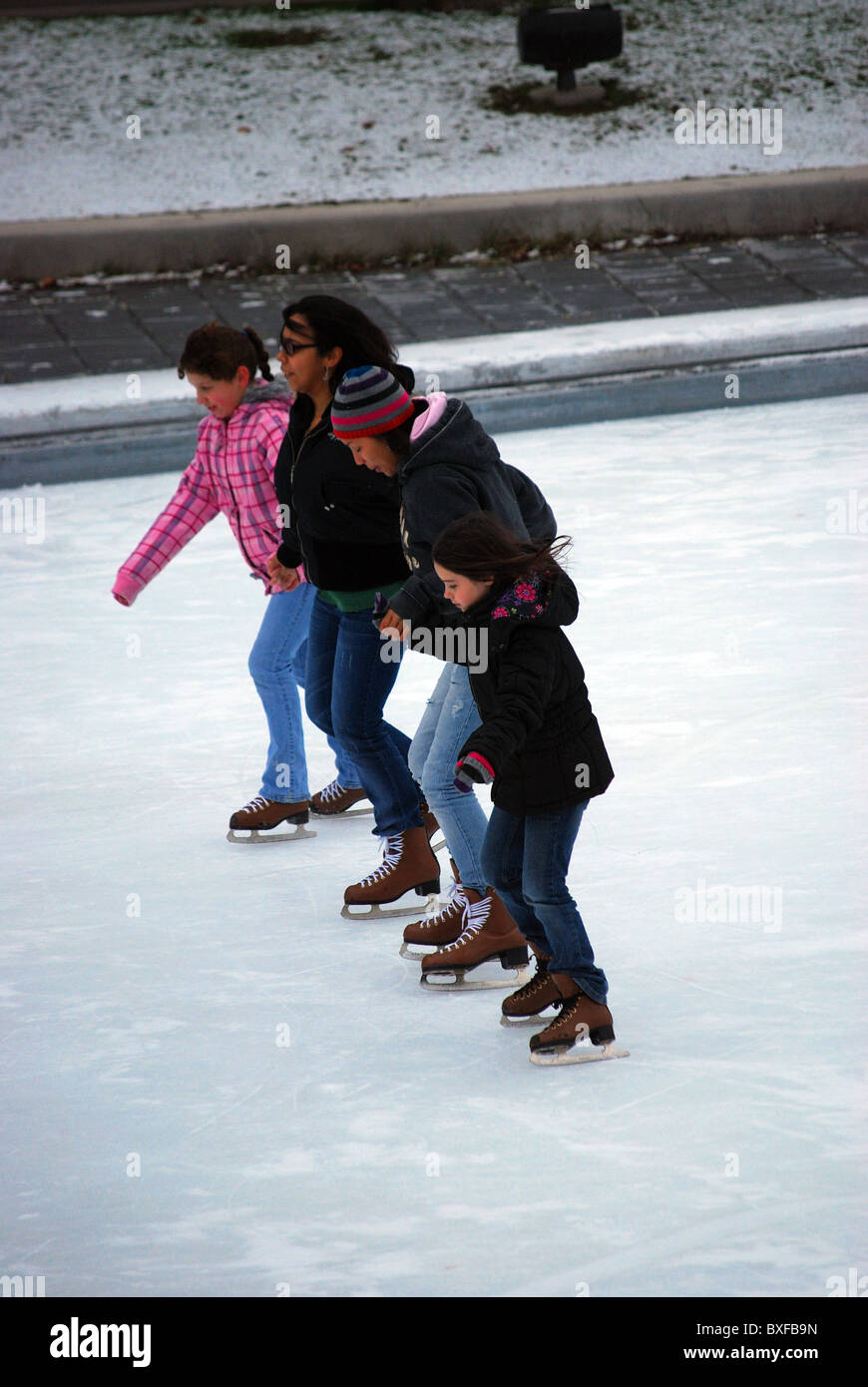 Four girls skate together on ice rink in Rochester, New York US Stock ...