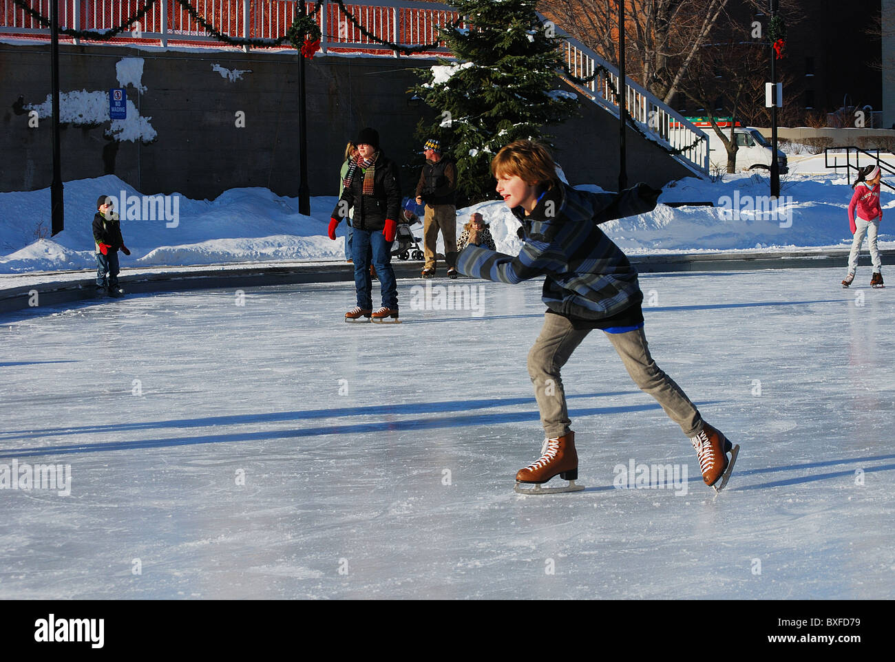 Young boy skating at urban ice rink Stock Photo - Alamy