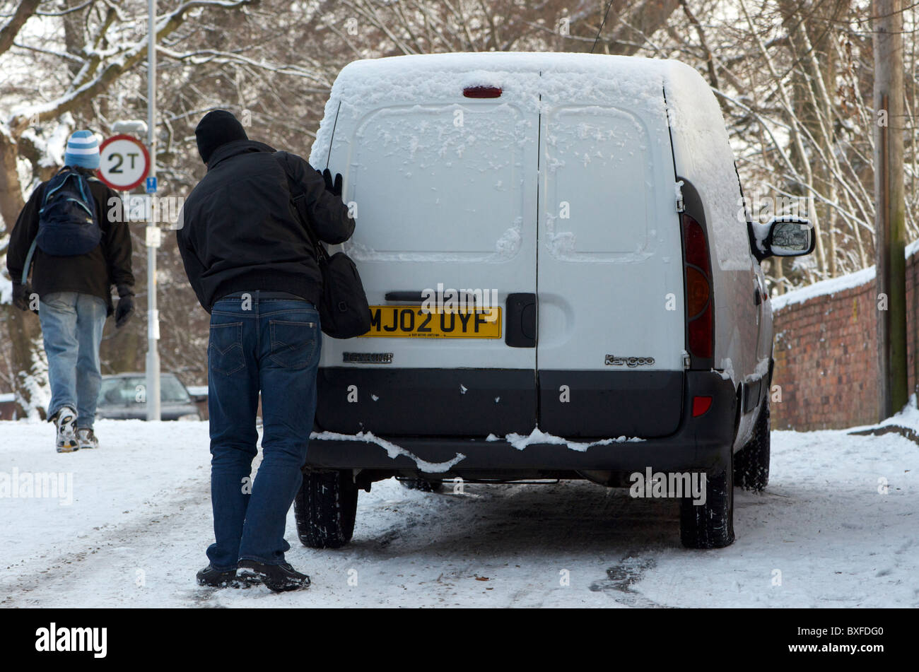 man pushing van up hill in snow and ice Stock Photo - Alamy