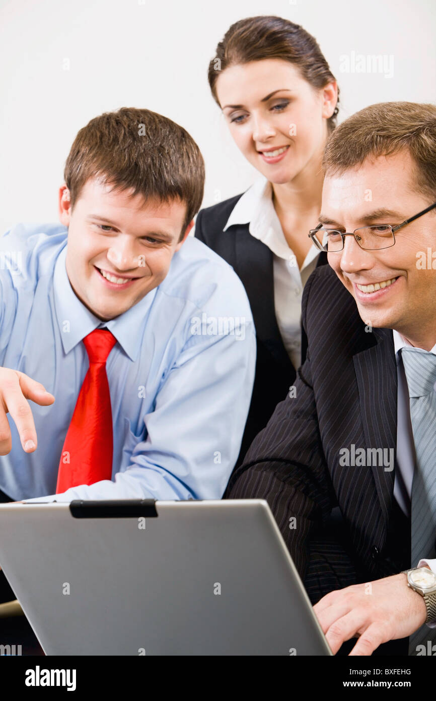 Business people gathered together around the laptop Stock Photo - Alamy