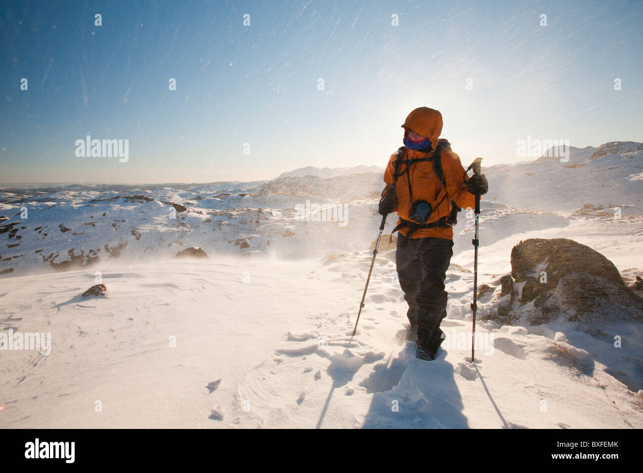 A climber being blasted by spindrift during high winds moving snow ...