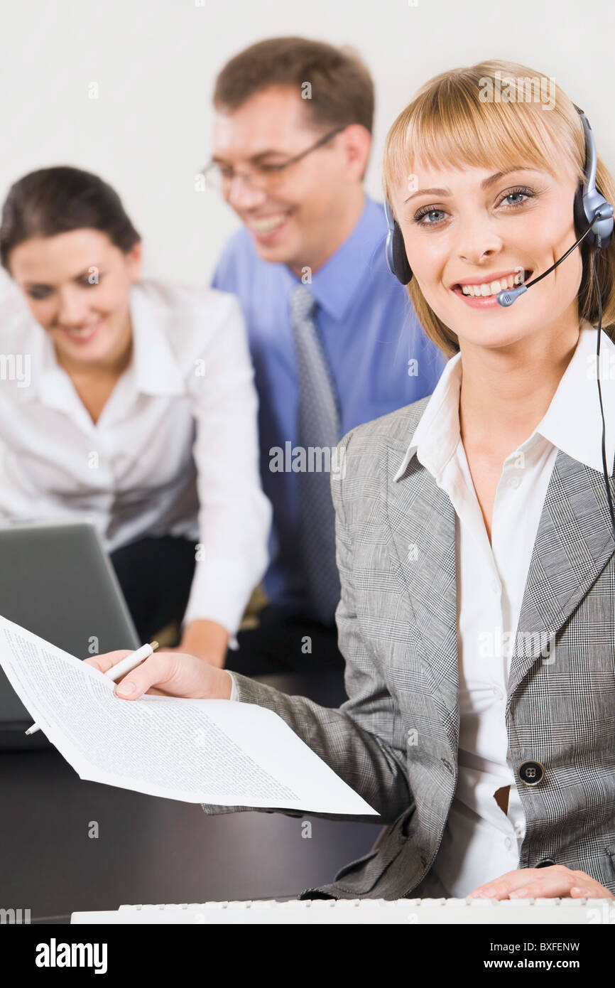 Portrait of pretty telephone operator holding paper and pen Stock Photo ...