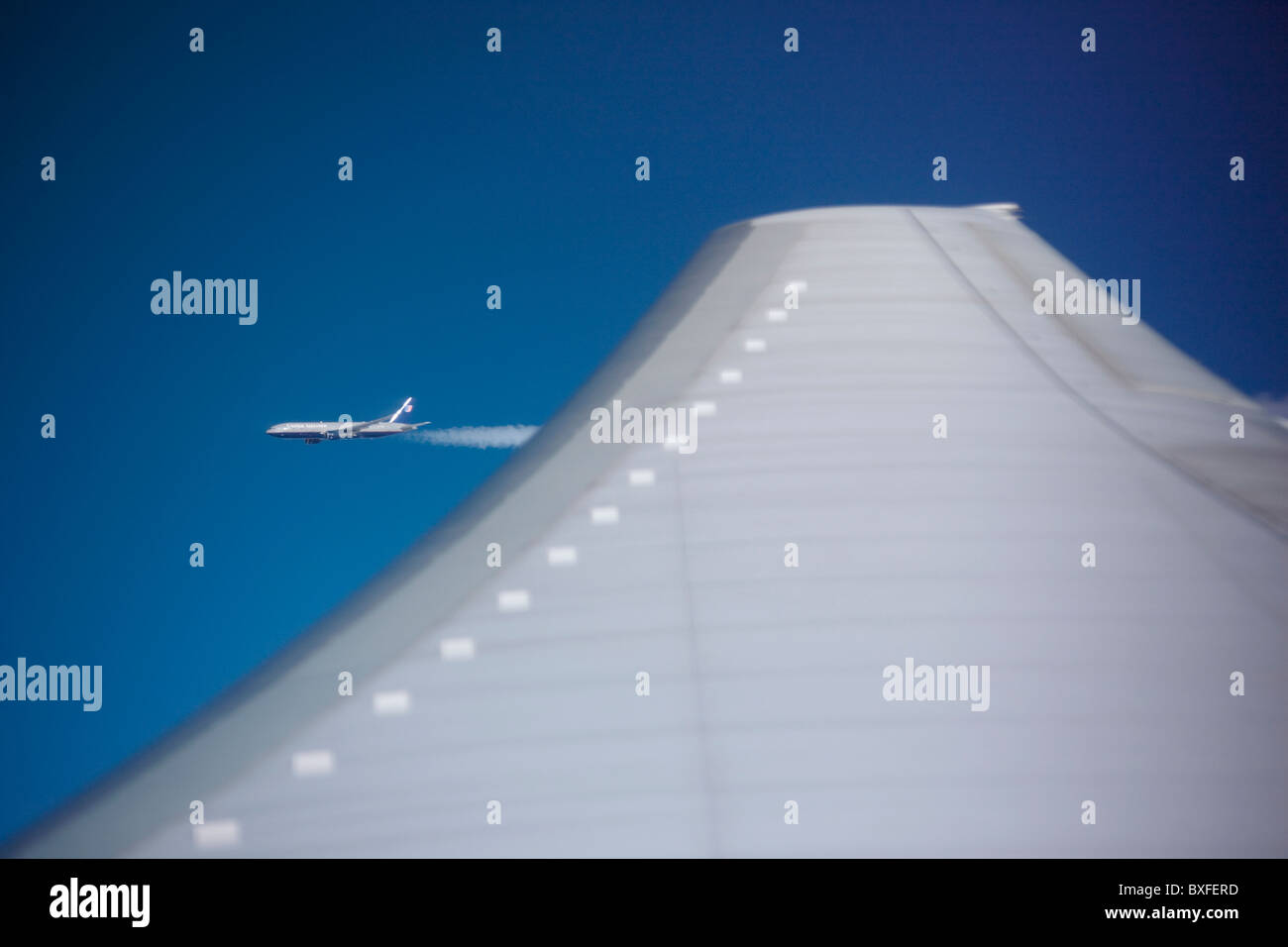 Passenger jet aircraft viewed across plane wing from porthole of ...