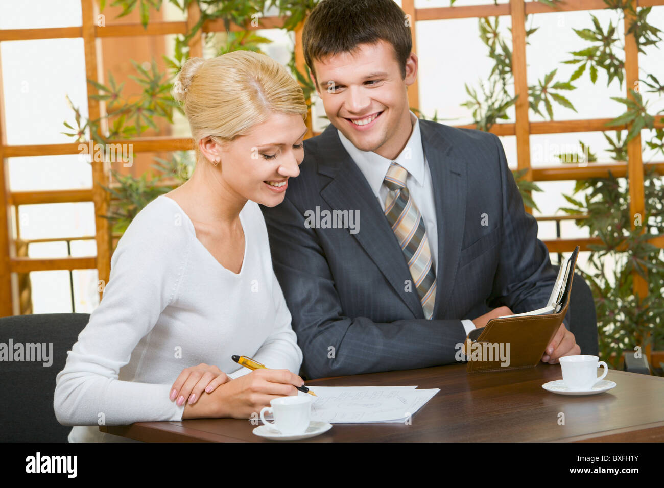 Portrait of two partners sitting at the table and chatting in the cafe ...