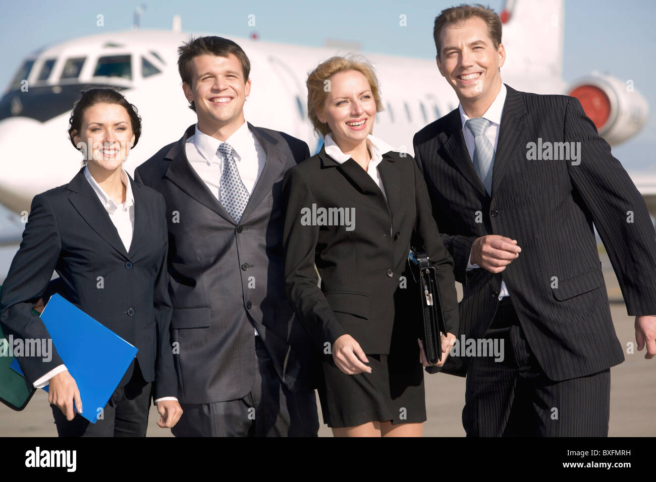 Group of four leaders smiling on the background of the airplane Stock ...