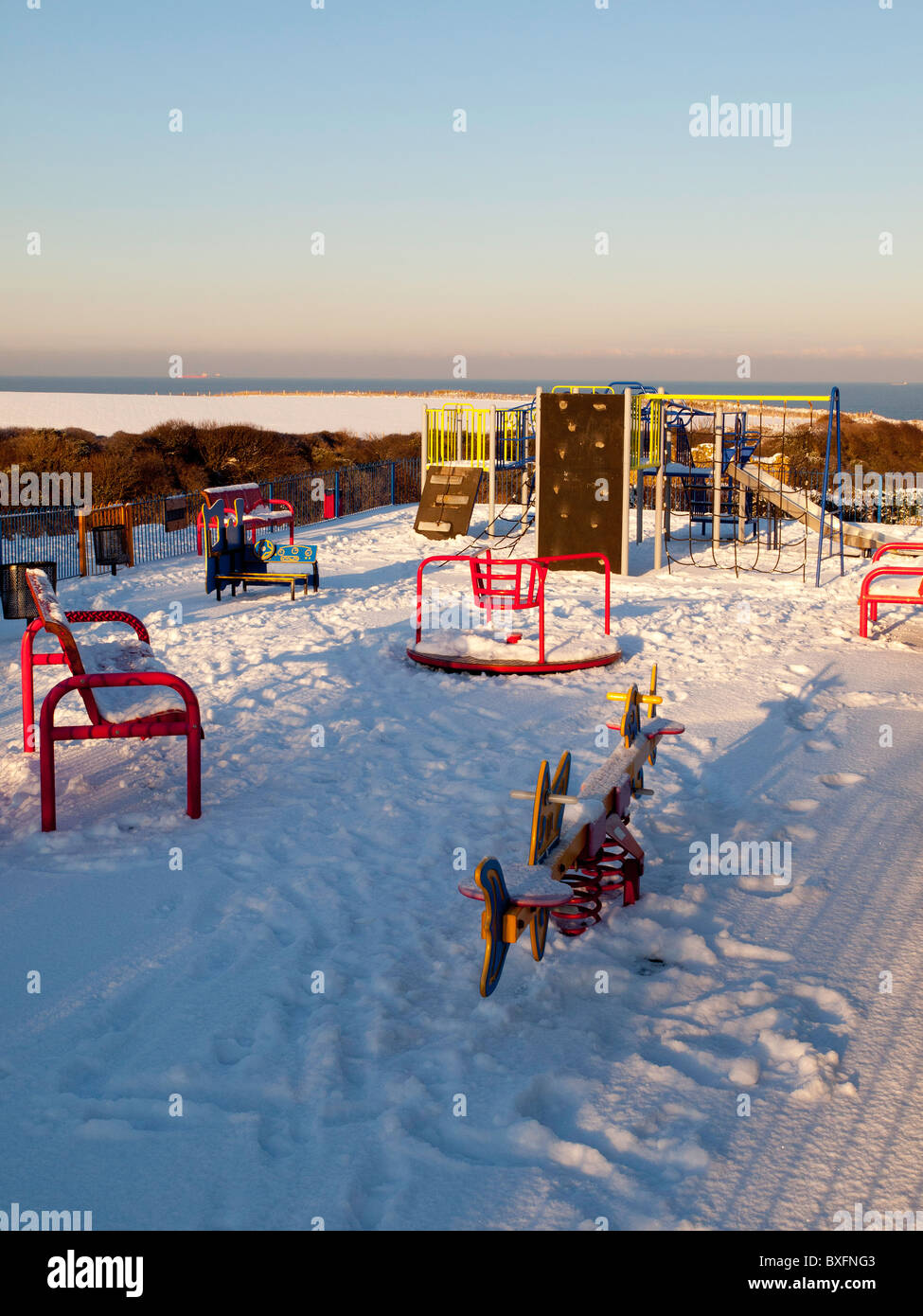 A modern well equipped children's playground covered in winter snow ...