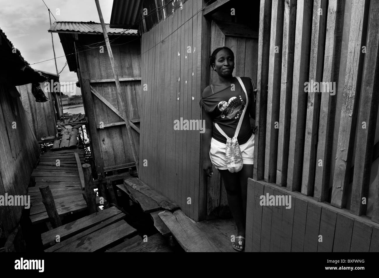 A displaced woman lives in a wooden house in the stilt house area in ...