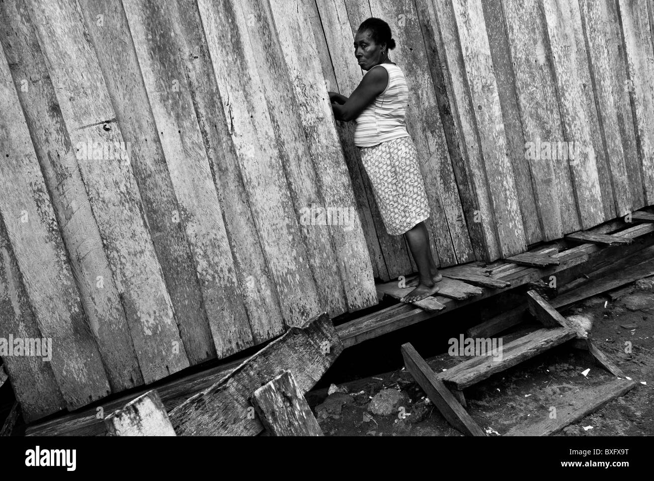 A displaced woman enters her wooden house in the stilt village close to ...