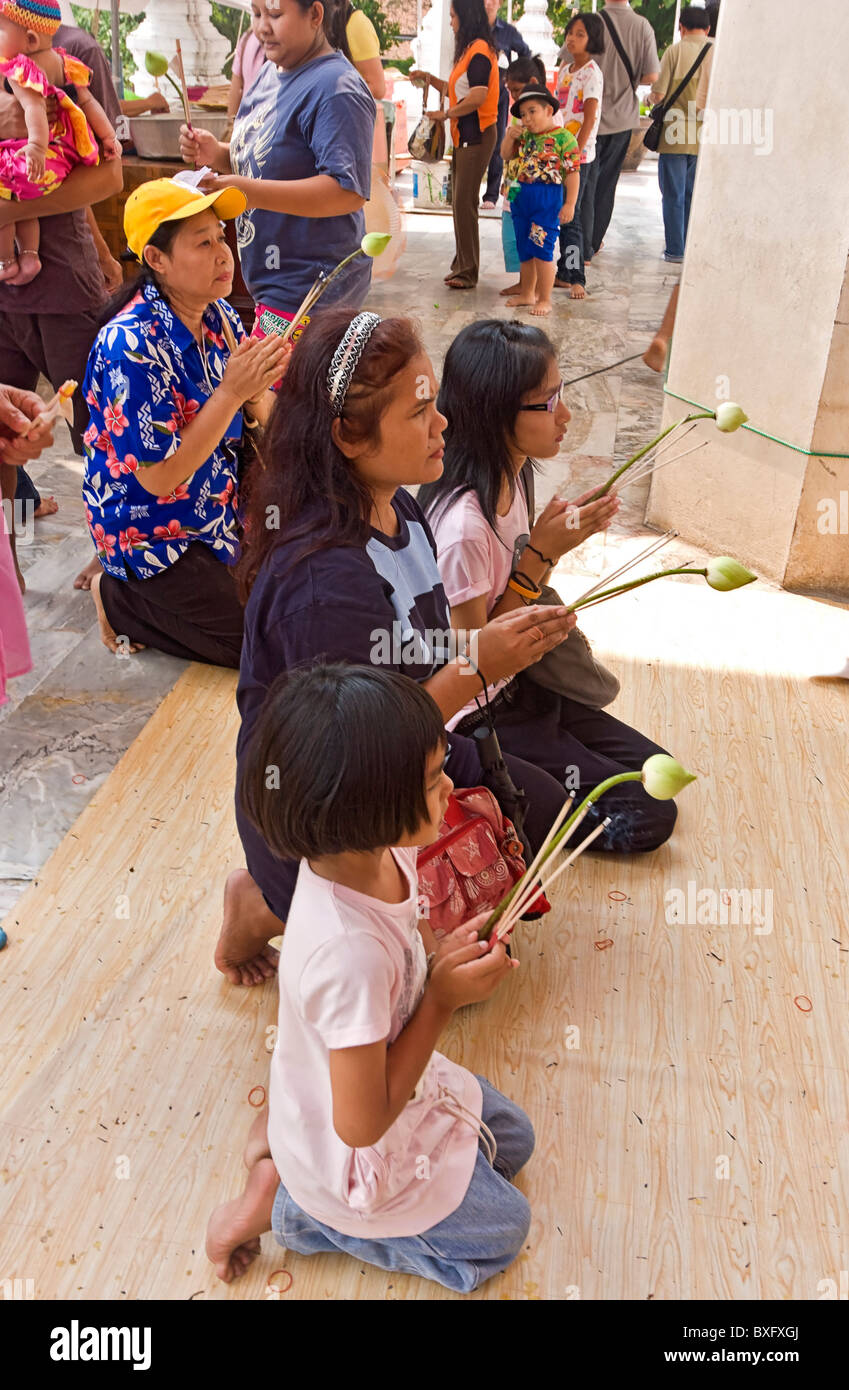 Buddhist worshipers hold lotus flower buds as offerings to Buddha at ...