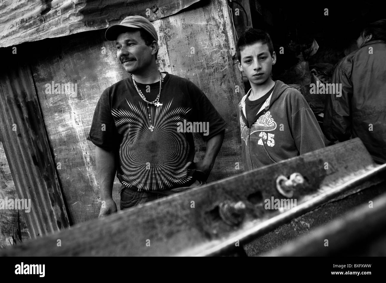 A displaced man with his son stands in front of their house in the slum ...