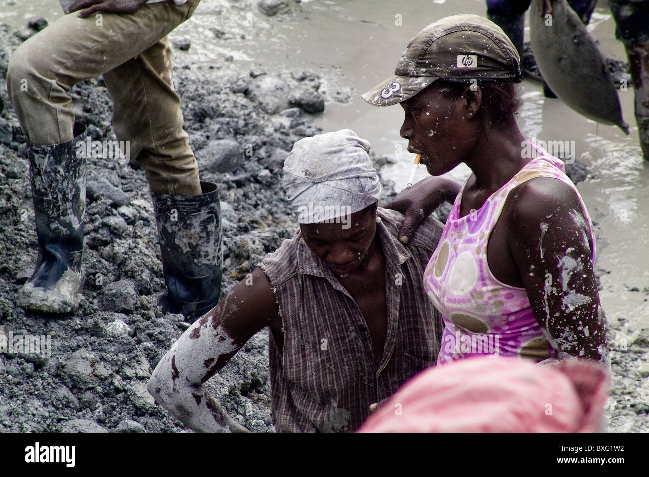 A woman gold miner having a short cigarette break during a hot day in ...