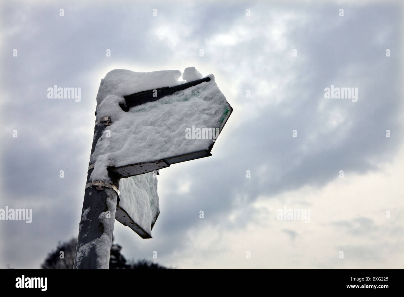 Snow covered signpost obscuring information Stock Photo - Alamy