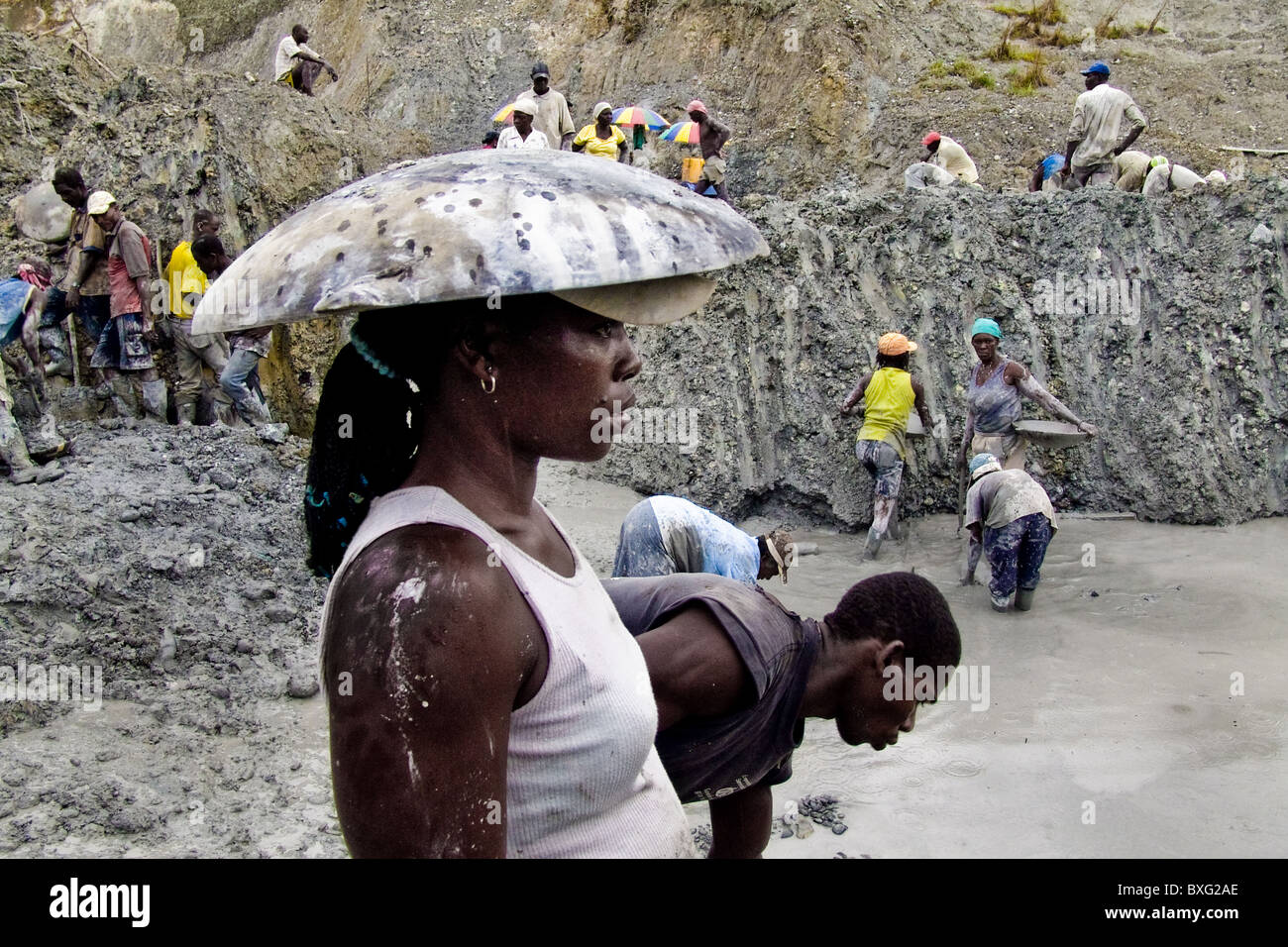 Hundreds of women gold miners digging the goldbearing mud in the open ...