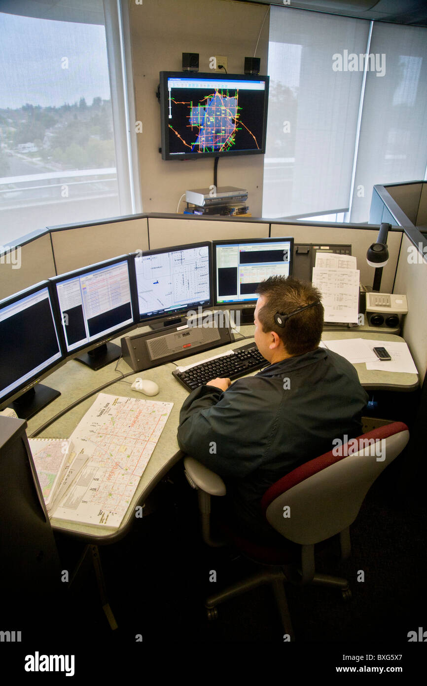 olice dispatcher works at a computer console handling incoming phone ...