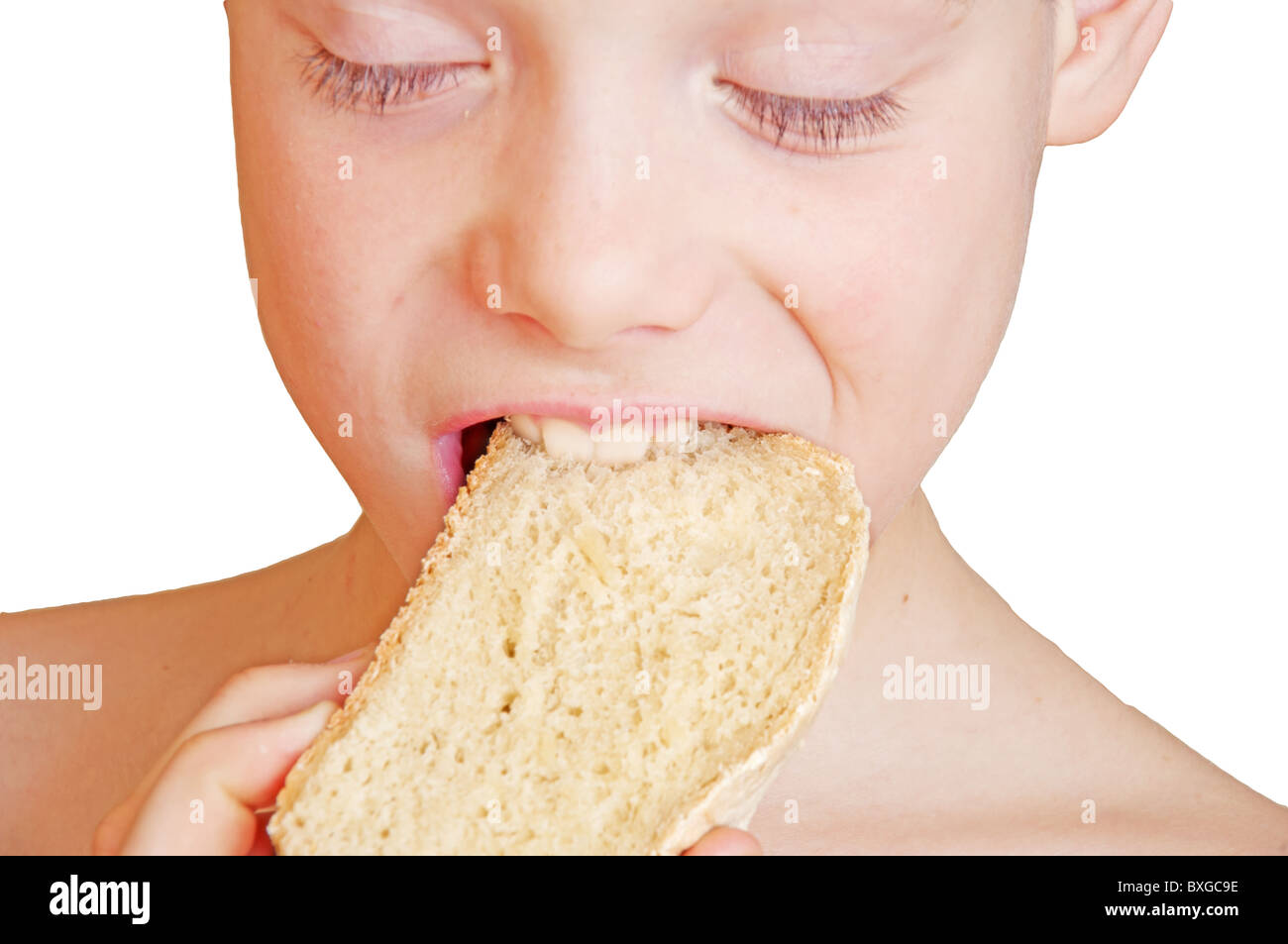 The child bites a piece of white fresh bread on a white background ...