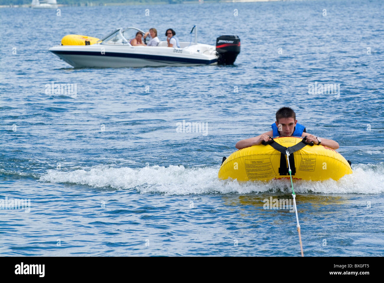 Boy riding an inflatable seabiscuit in the sea, Biscarrosse, France ...