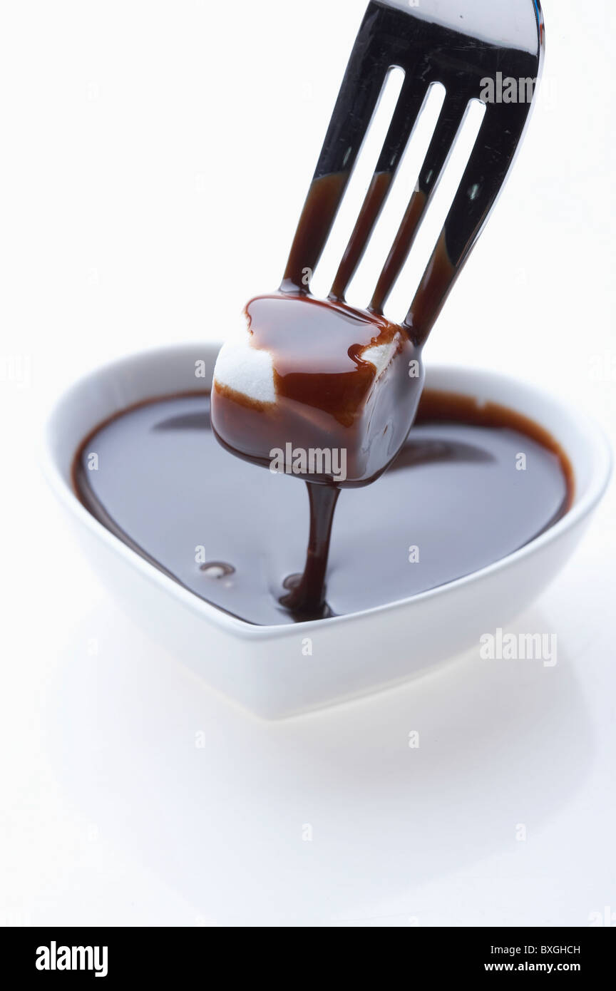 sugar cube dipped in melted chocolate Stock Photo - Alamy