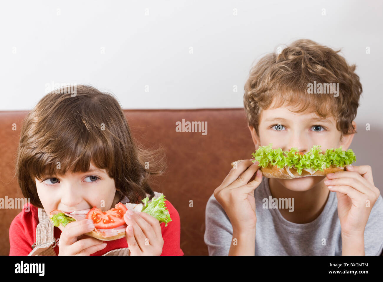 Girl and boy eating sandwiches Stock Photo - Alamy