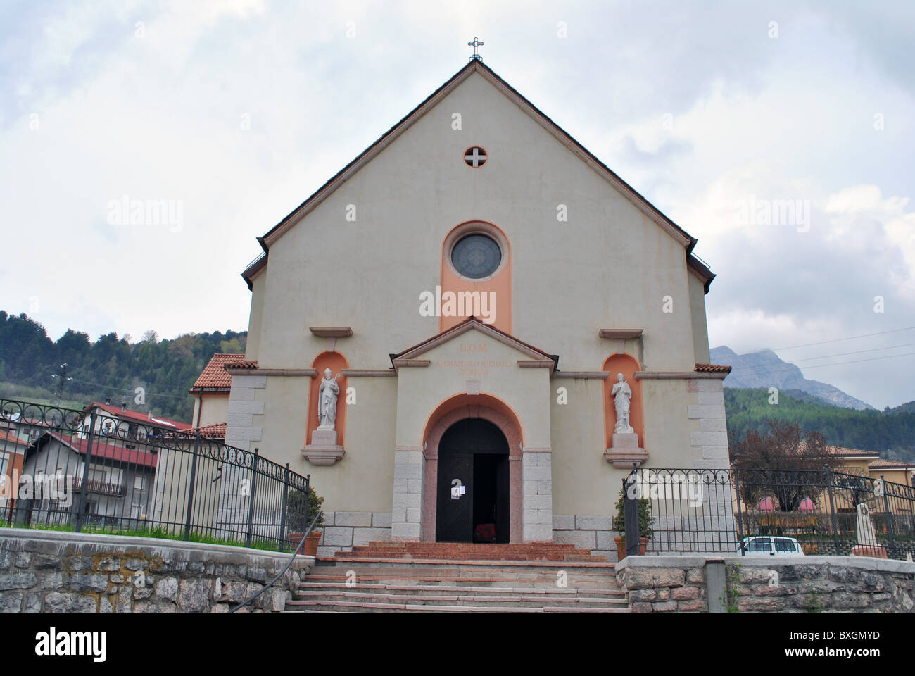 Alpine church with a gate, with trees and mountain background Stock ...