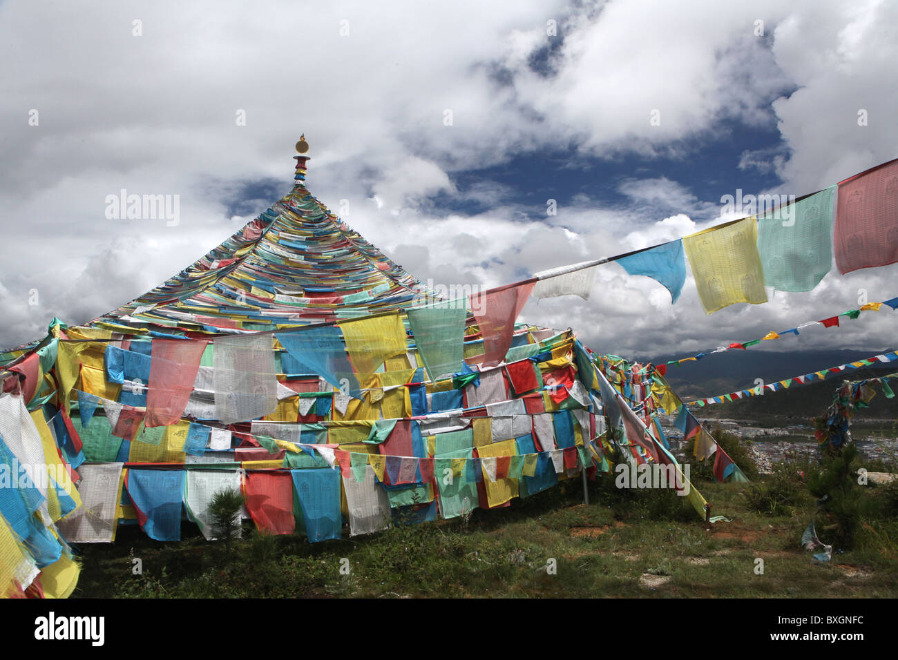 A temple covered in tibetan flags above the town of Shangri La in ...
