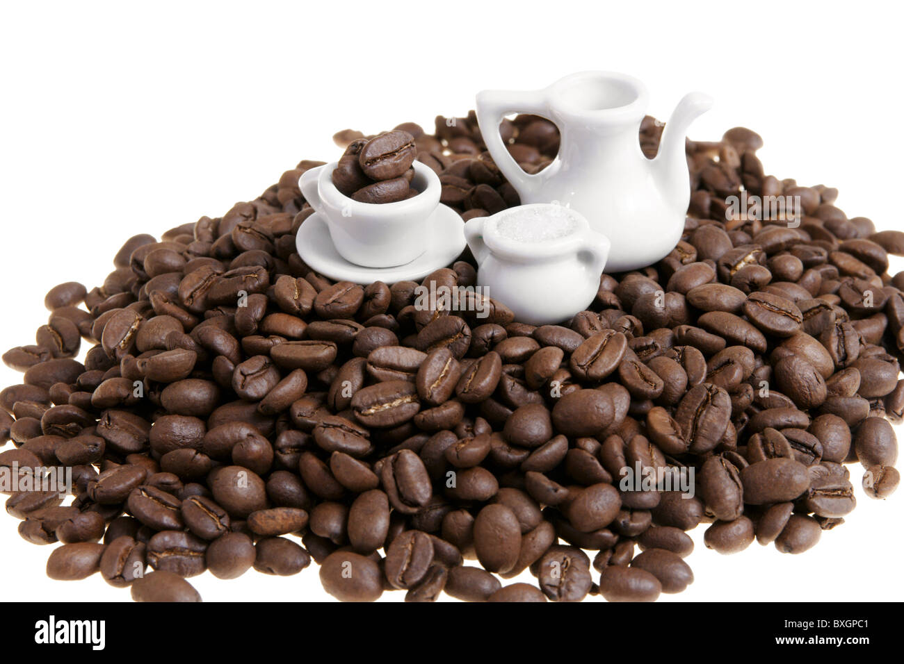 Stack of coffe beans with miniature coffee service Stock Photo - Alamy