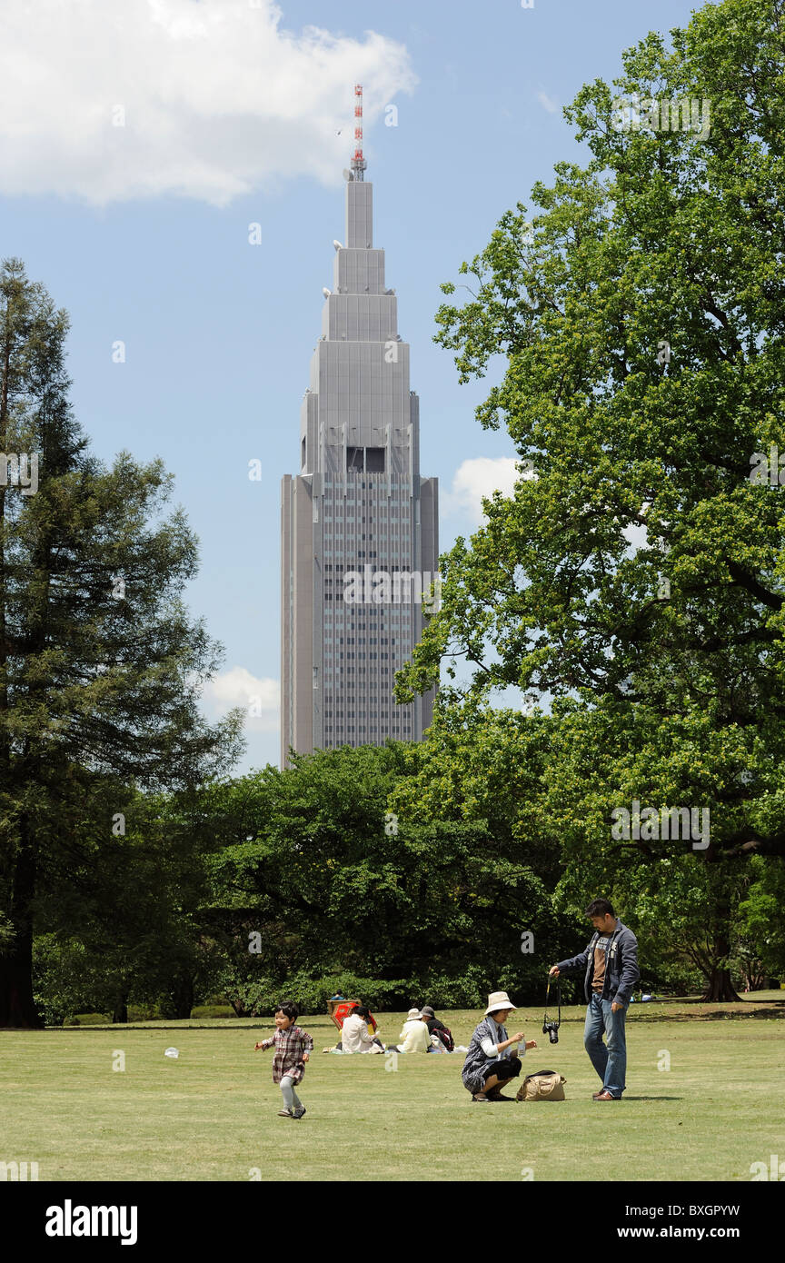 Japanese family in Shinjuku Park with DoCoMo tower in the background ...