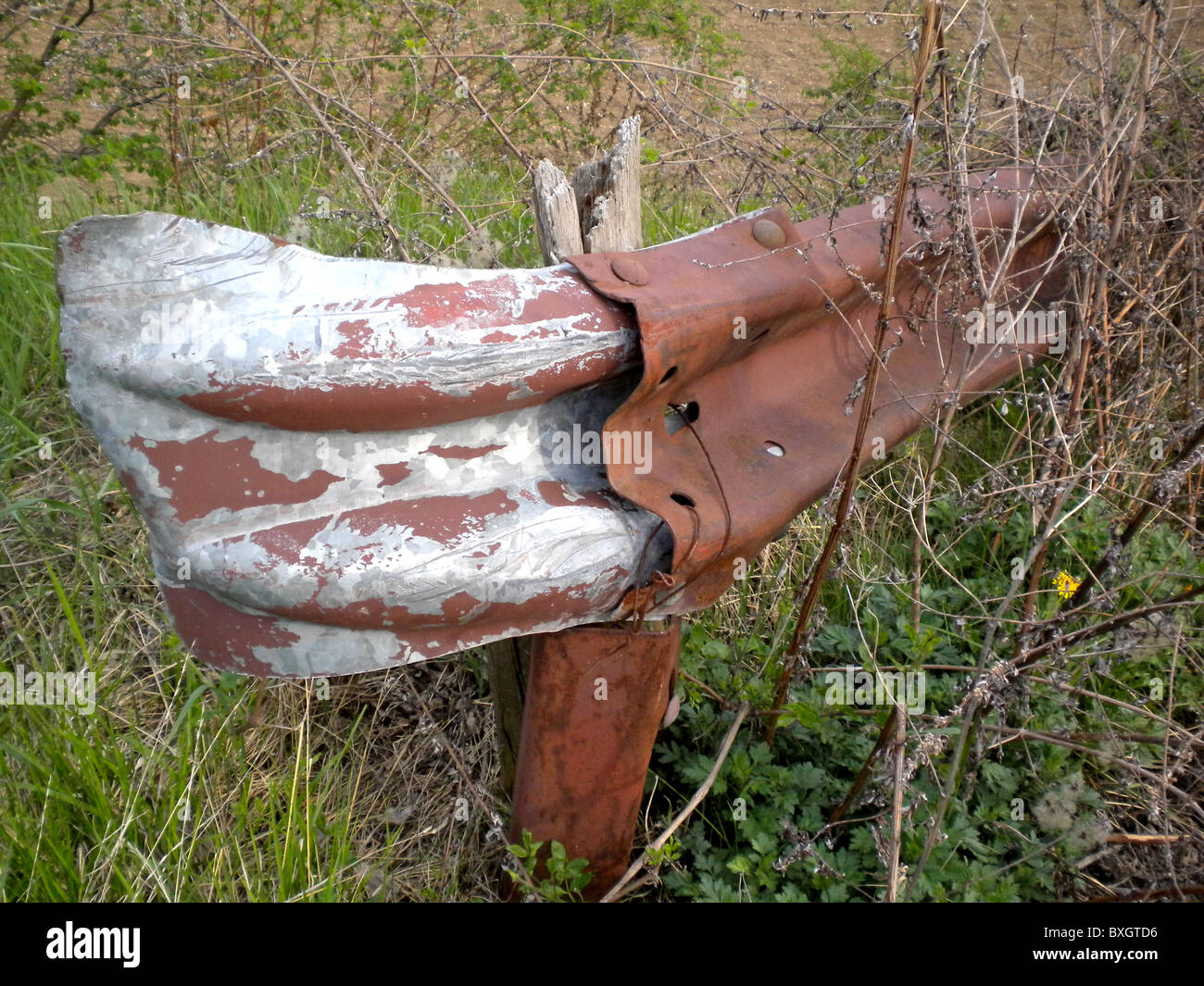 guard rail damaged and worn on a country road little used Stock Photo ...