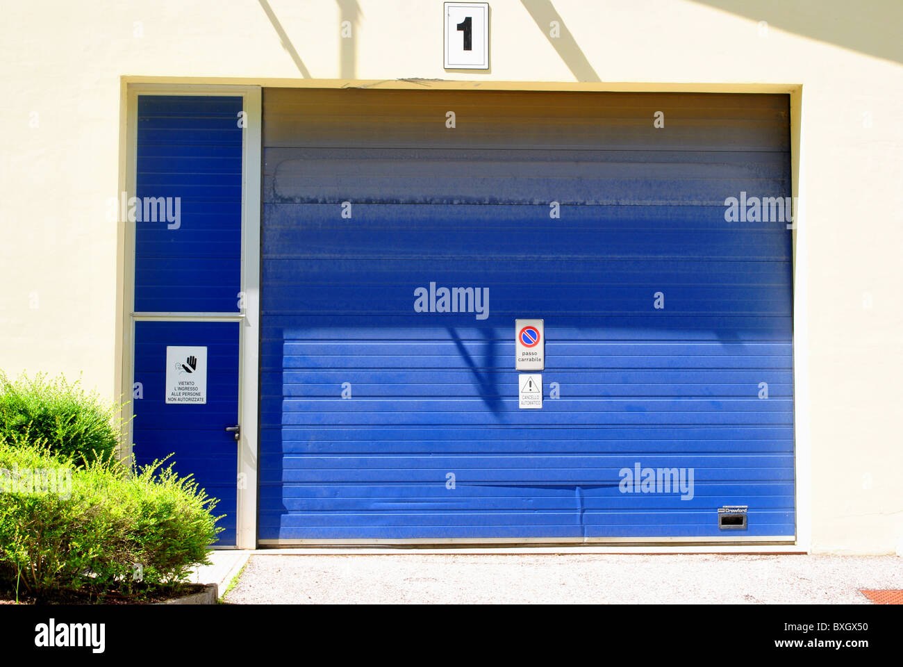 garage and store small craft company with blue gate Stock Photo - Alamy
