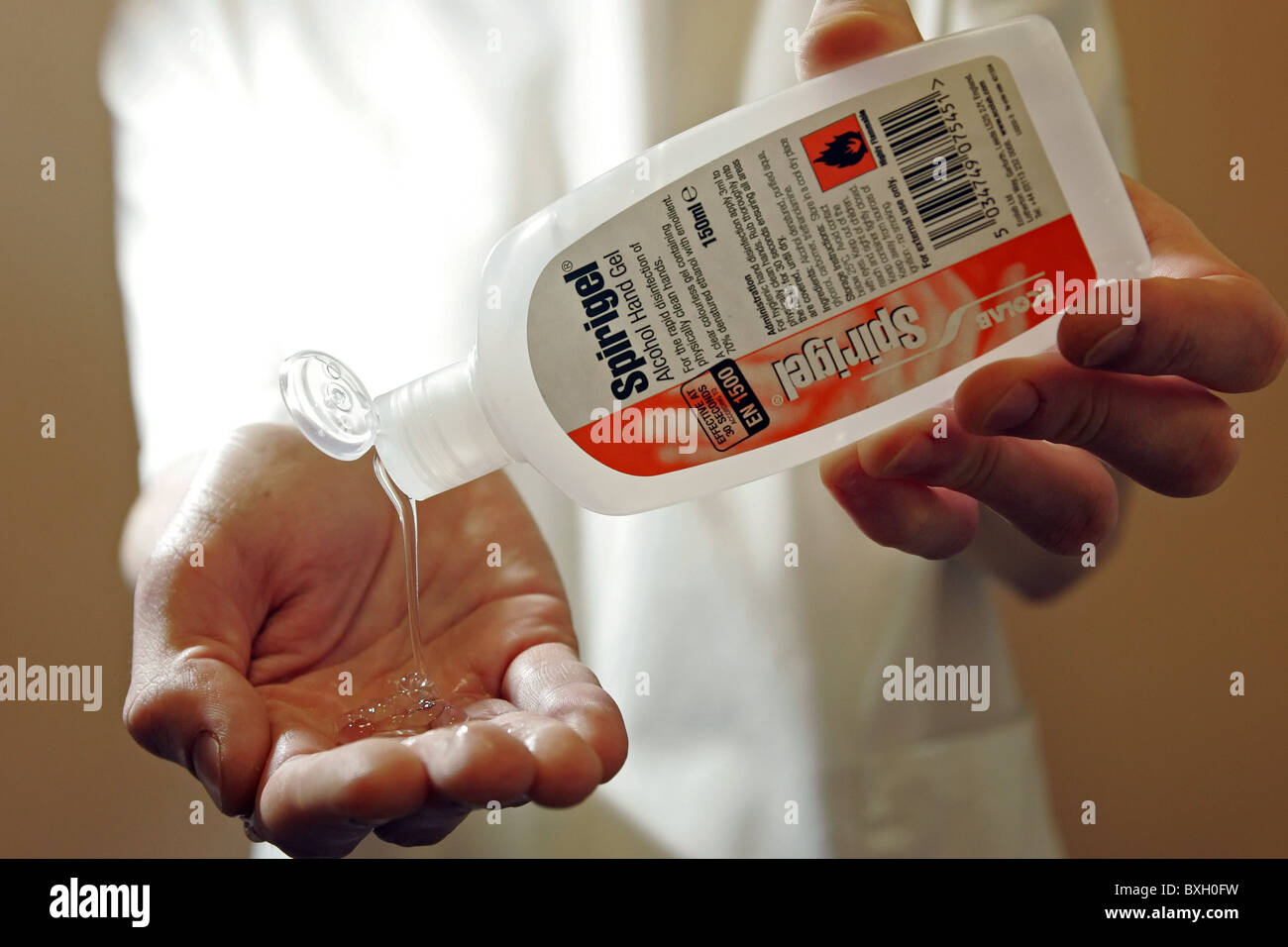 A male nurse demonstrates the use of alcohol based hand gel for ...