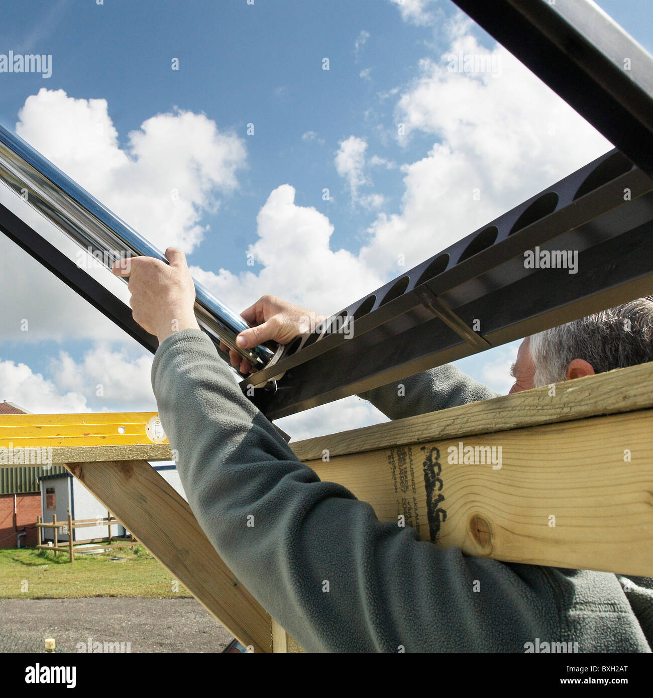 Fixing tubes into a solar powered heating system Stock Photo - Alamy