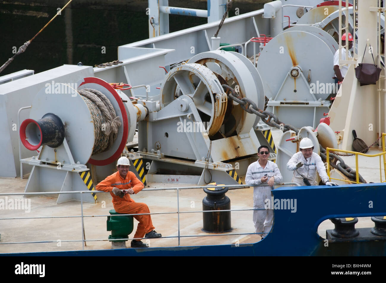 Workers on a cargo ship smile at onlookers while the ship passes ...