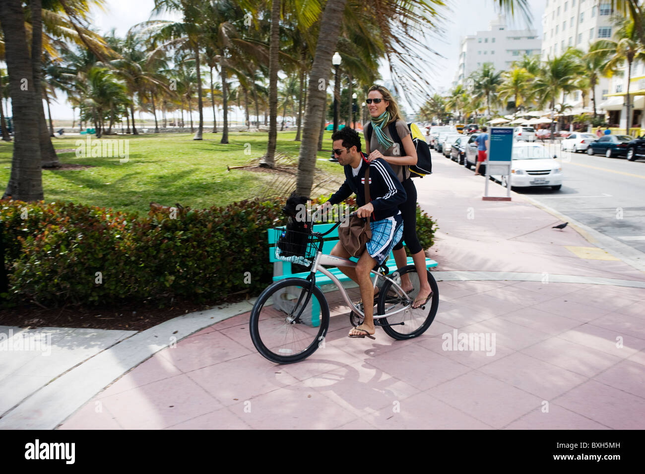 Young couple sharing a bicycle on Ocean Drive, South Beach, Miami ...