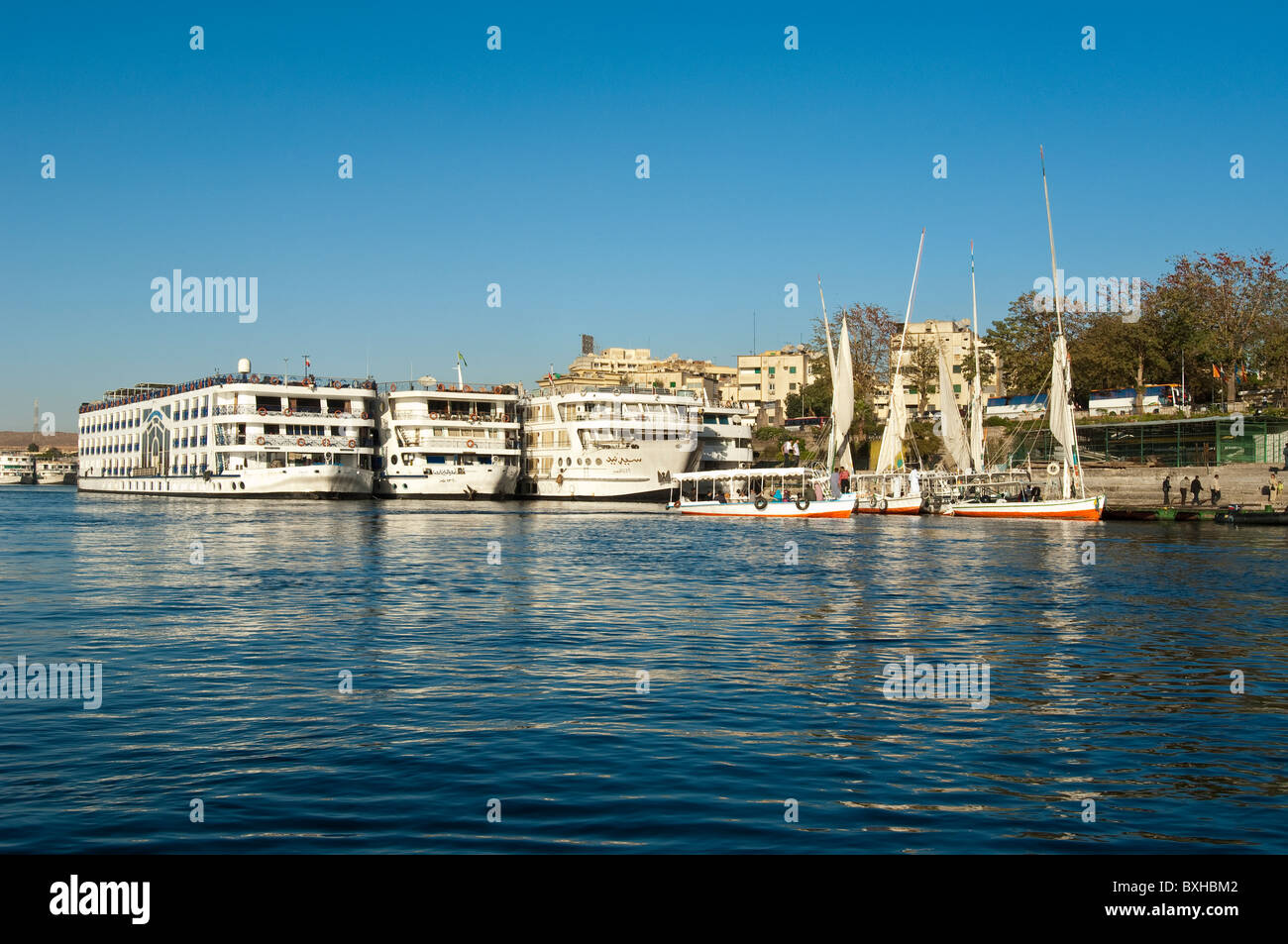Egypt, Aswan. Felucca and cruise ships sailing on the Nile near Aswan ...