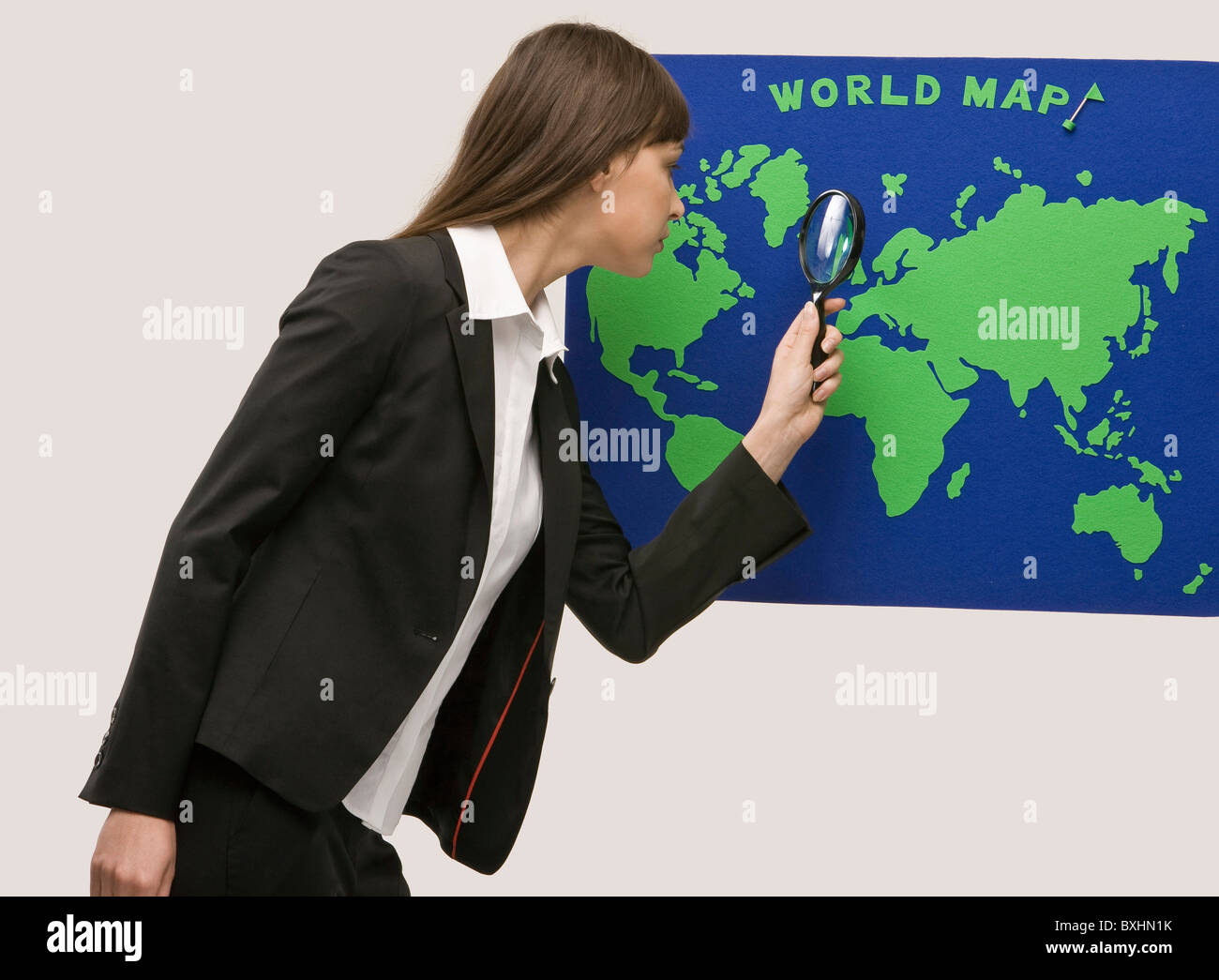 Businesswoman looking at map with magnifying glass Stock Photo - Alamy