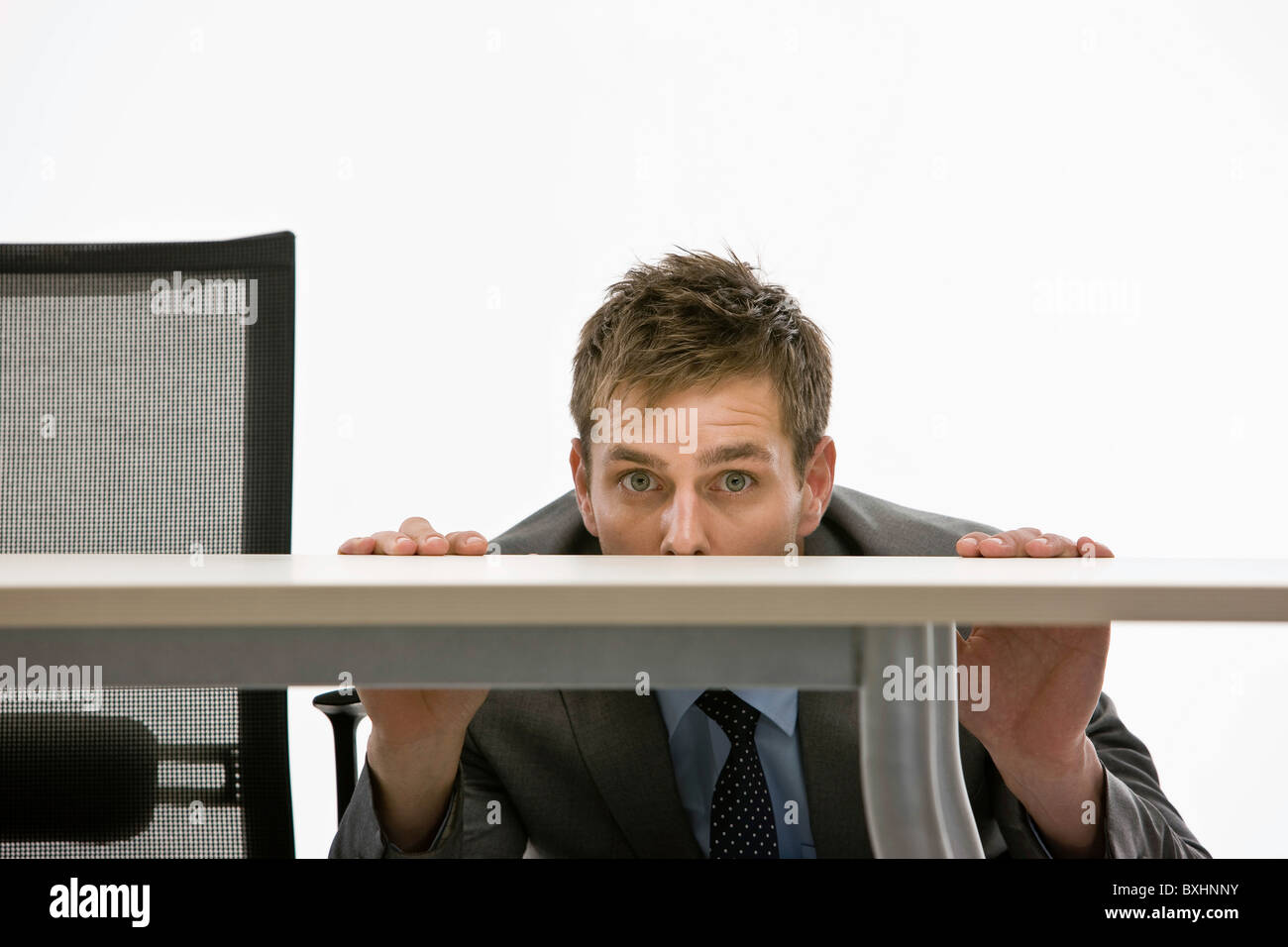 Businessman hiding under table hi-res stock photography and images - Alamy