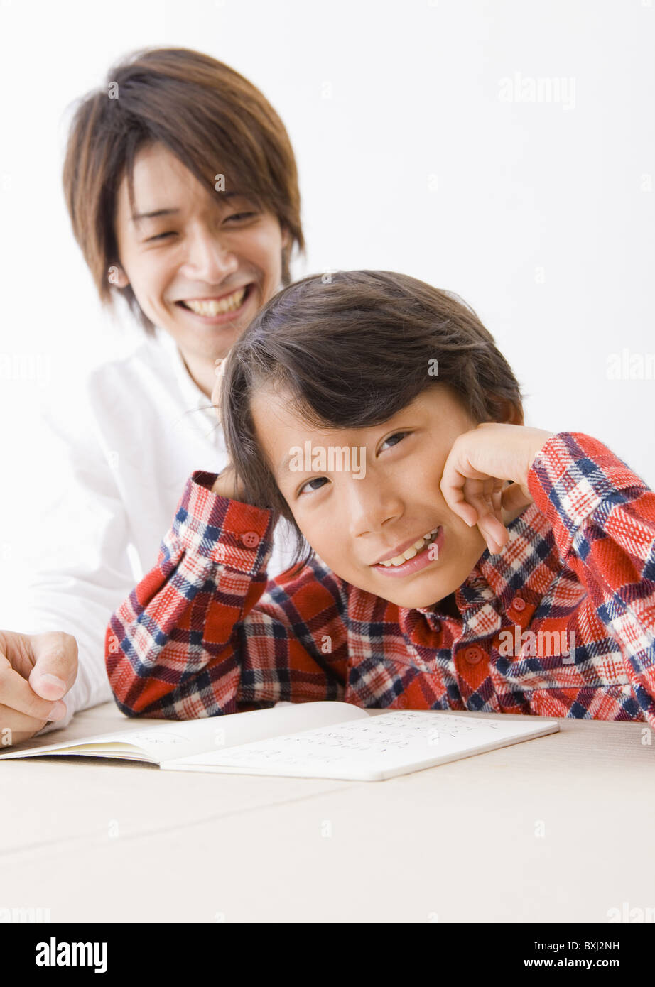 A boy studying with his father Stock Photo - Alamy
