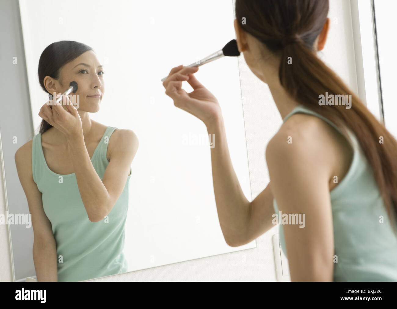 A woman putting on blusher Stock Photo - Alamy