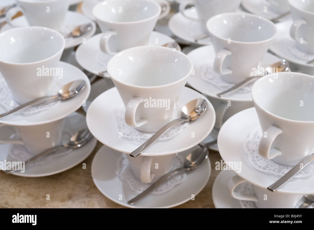 many empty tea cups on saucers with teaspoons Stock Photo - Alamy