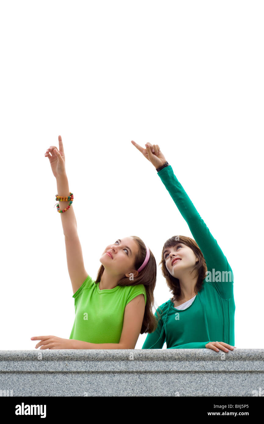 beautiful young european girls lean their elbows on banister and point ...