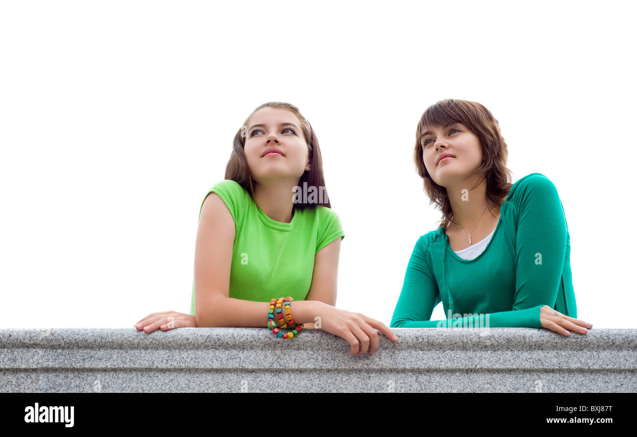 two young beautiful european girls lean their elbows on banister and ...